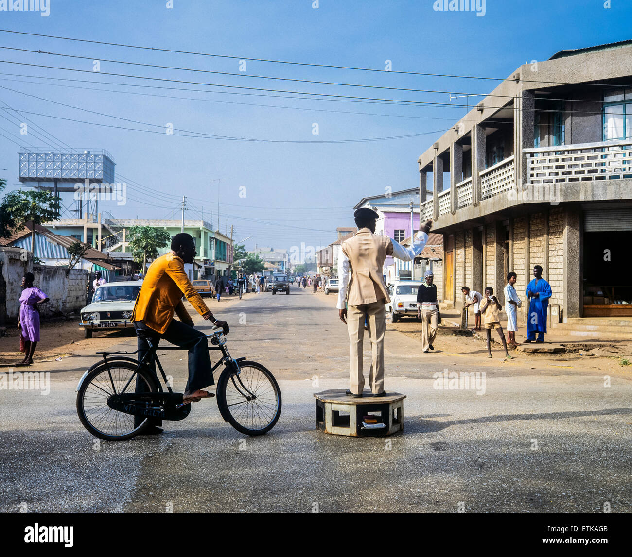 Gambian man with bike and policeman directs traffic, Banjul, Gambia ...