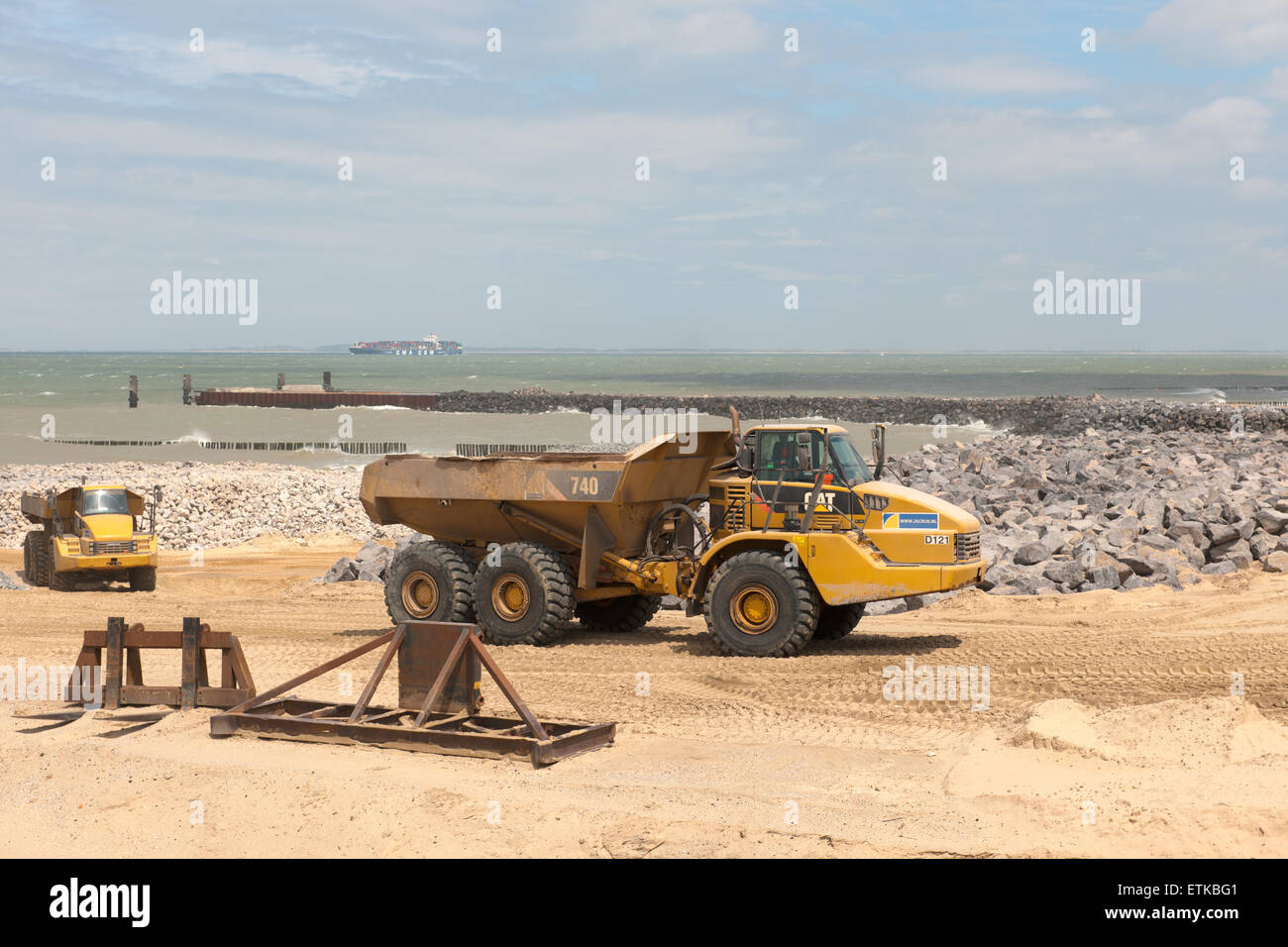 Heavy vehicles working on the coastal protection along the Dutch coast ...