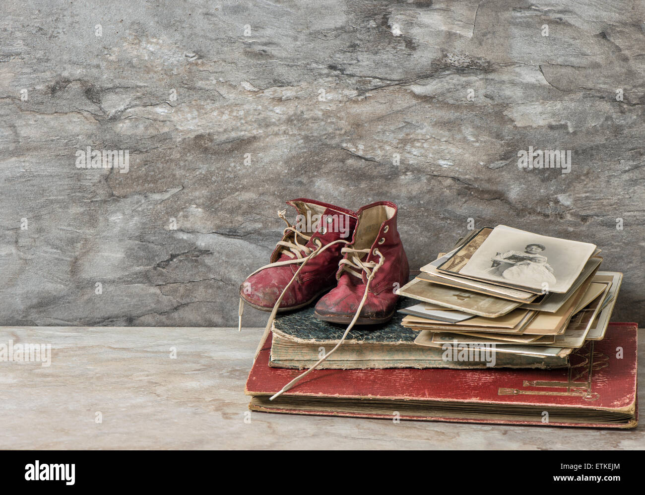 Antique books, photos, and baby shoes. Nostalgic still life with stone background Stock Photo ...