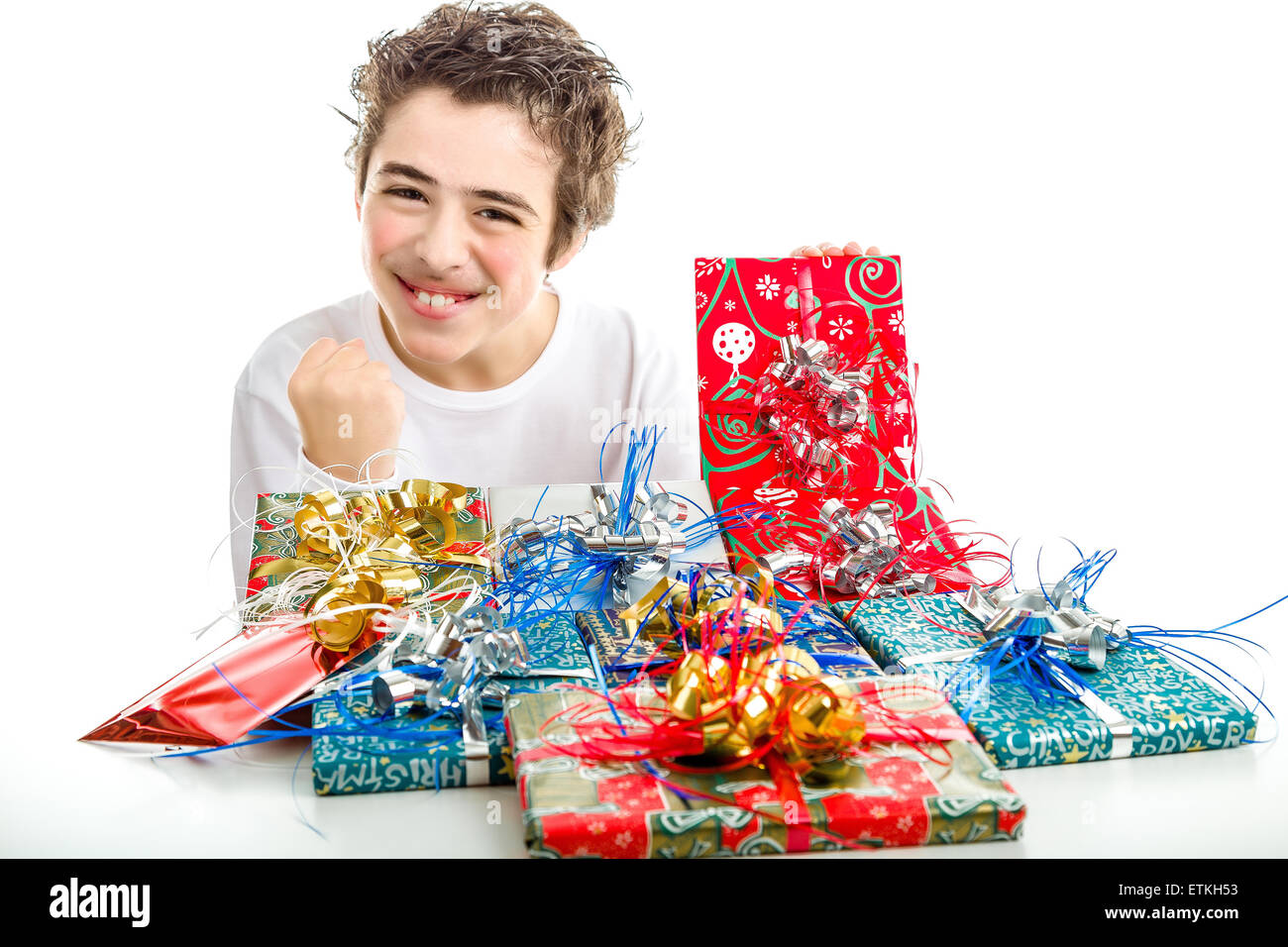 A happy boy makes success sign receiving several Christmas gifts in ...