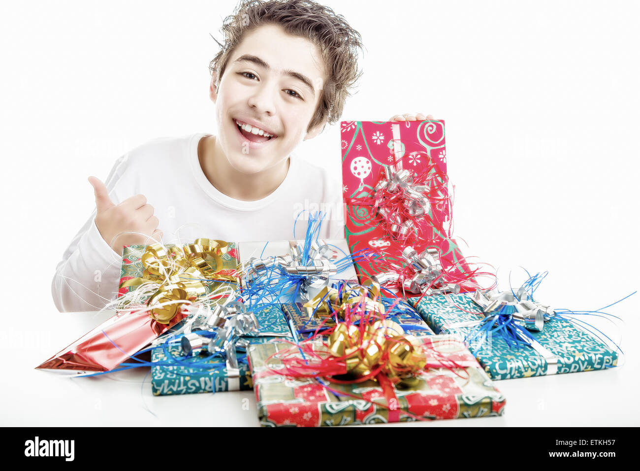 A happy boy makes success sign with thumb while receiving several ...