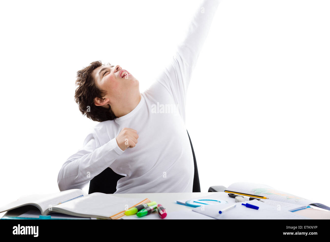 Latin Caucasian Teenager boy sitting while doing homework is happy and ...
