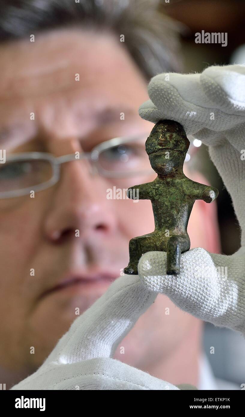 An around 1800-year-old Germanic god statue is examined by ...