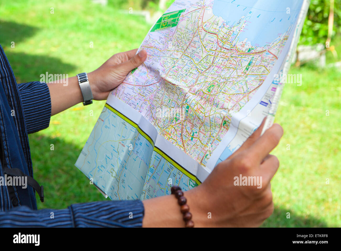 Man hand looking at map for direction Stock Photo - Alamy