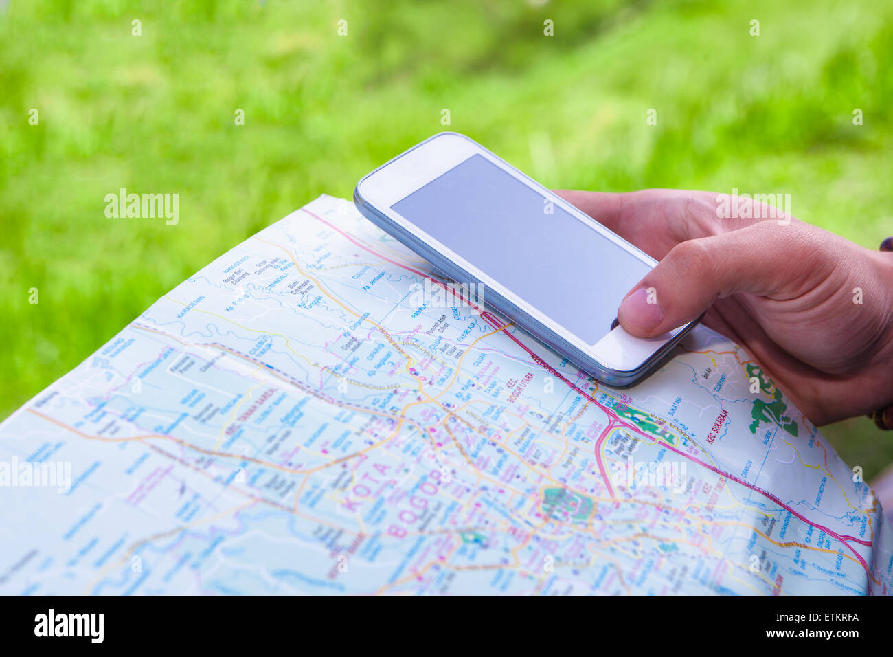 Man hand looking direction with maps and mobile phone Stock Photo - Alamy