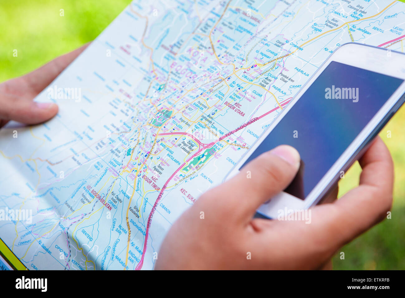 Man hand looking direction with maps and mobile phone Stock Photo - Alamy