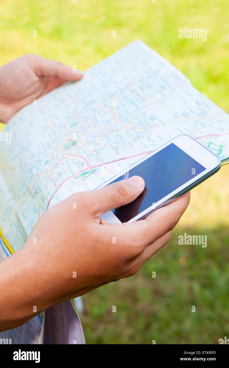Man hand looking direction with maps and mobile phone Stock Photo - Alamy