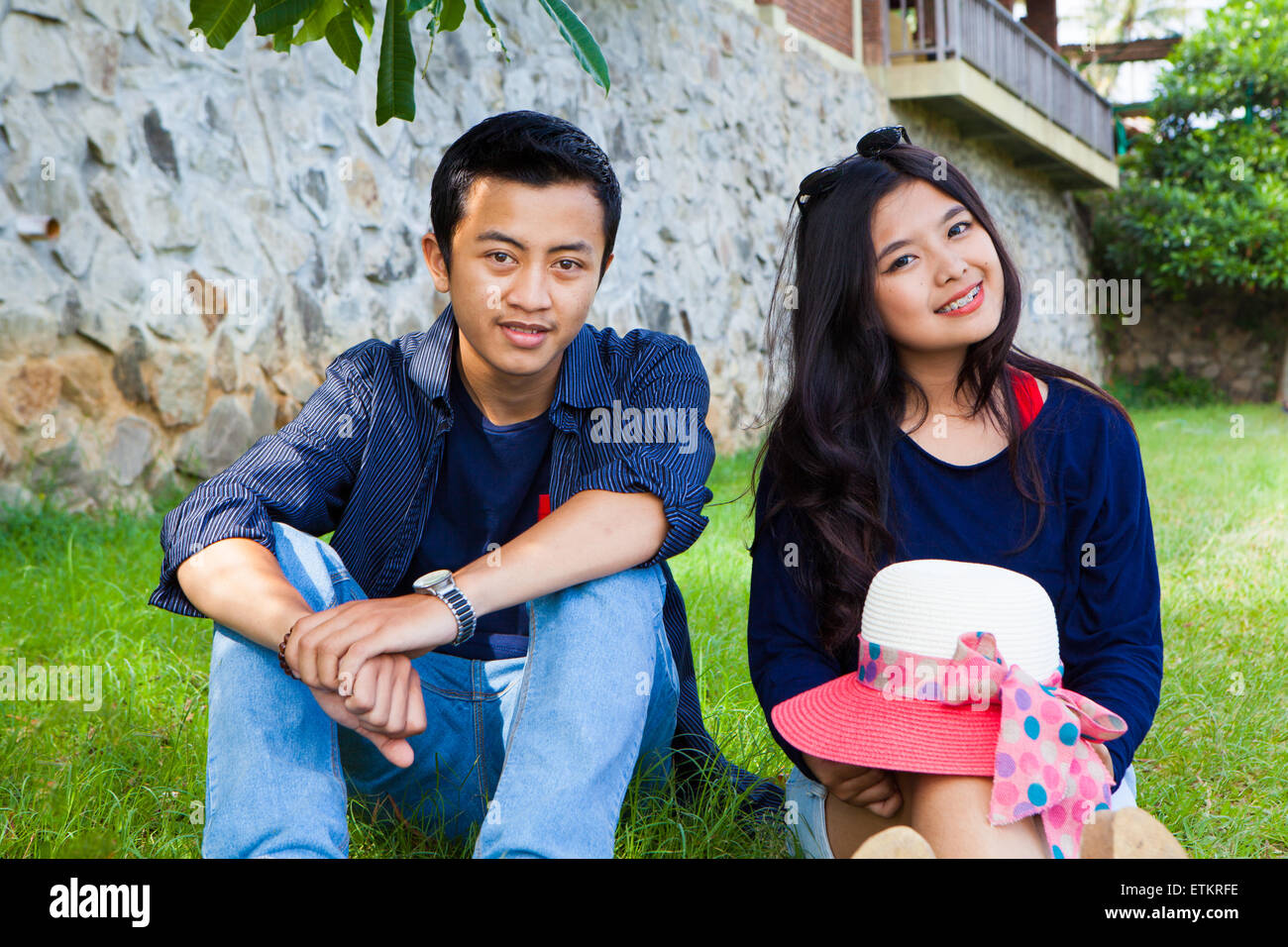 Asian Happy couple relaxing on green grass outdoor Stock Photo - Alamy
