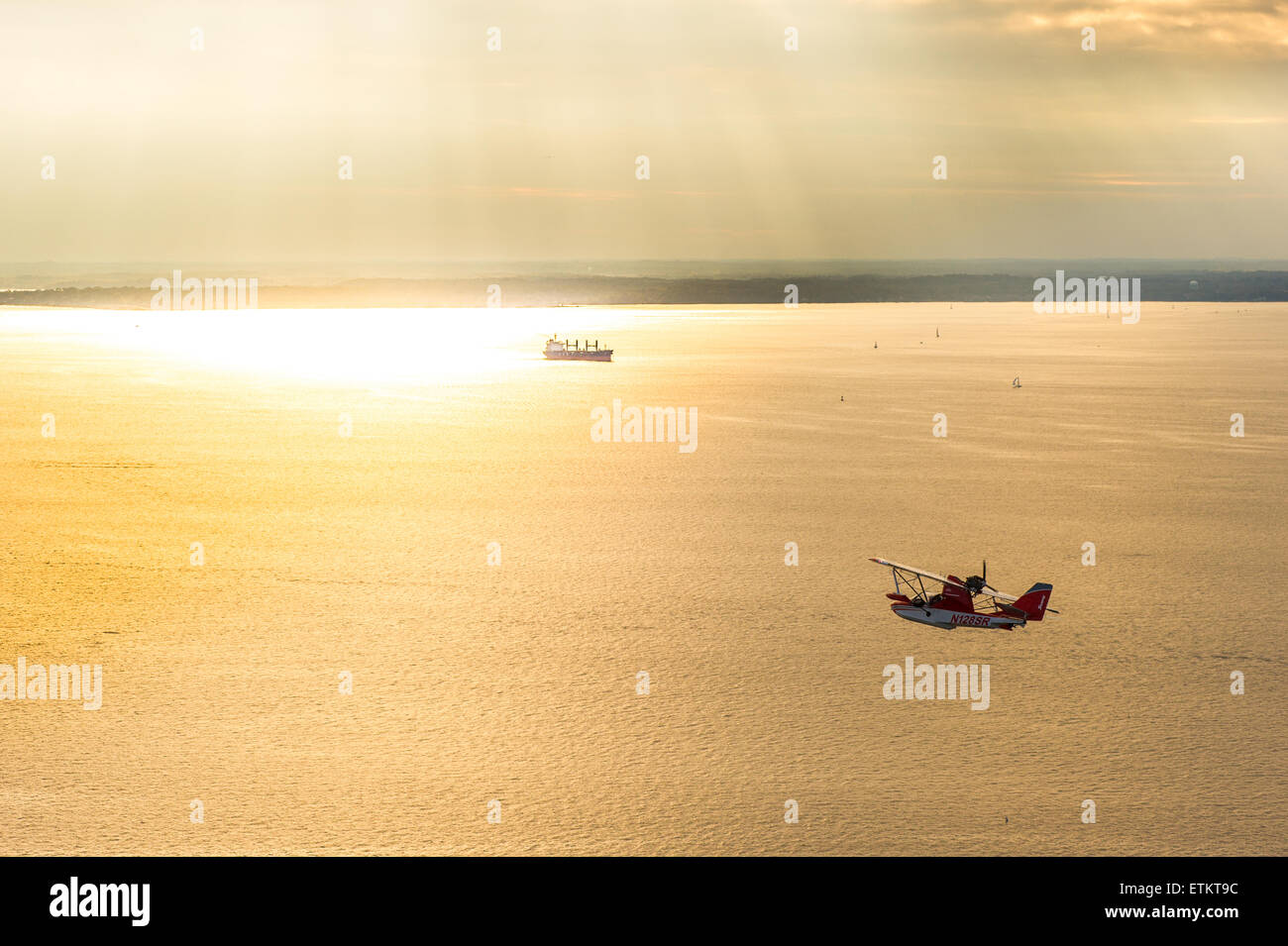 Searey a small seaplane flying over the Chesapeake Bay, during a sunset ...