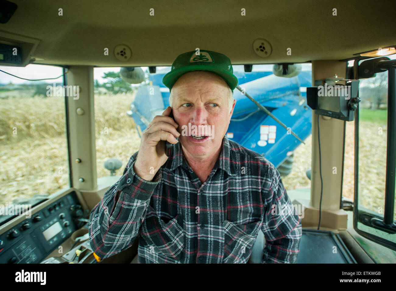 Farmer speaking on his cell phone in his tractor cab in Jarrettsville ...