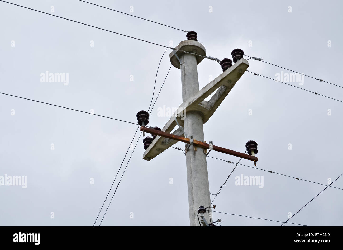 Closeup of simple three-phase electric pole with the sky in background ...