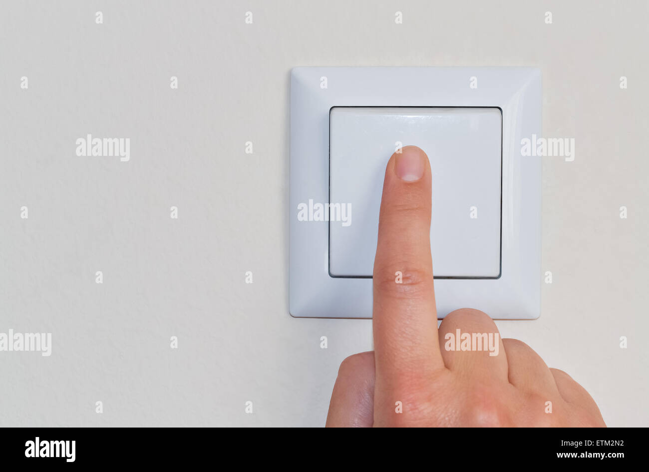 A hand of a woman pressing a wall mounted light switch Stock Photo - Alamy