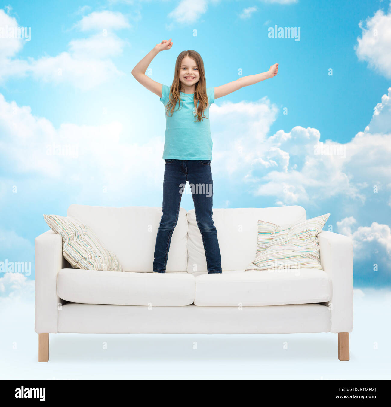 smiling little girl jumping on sofa Stock Photo - Alamy