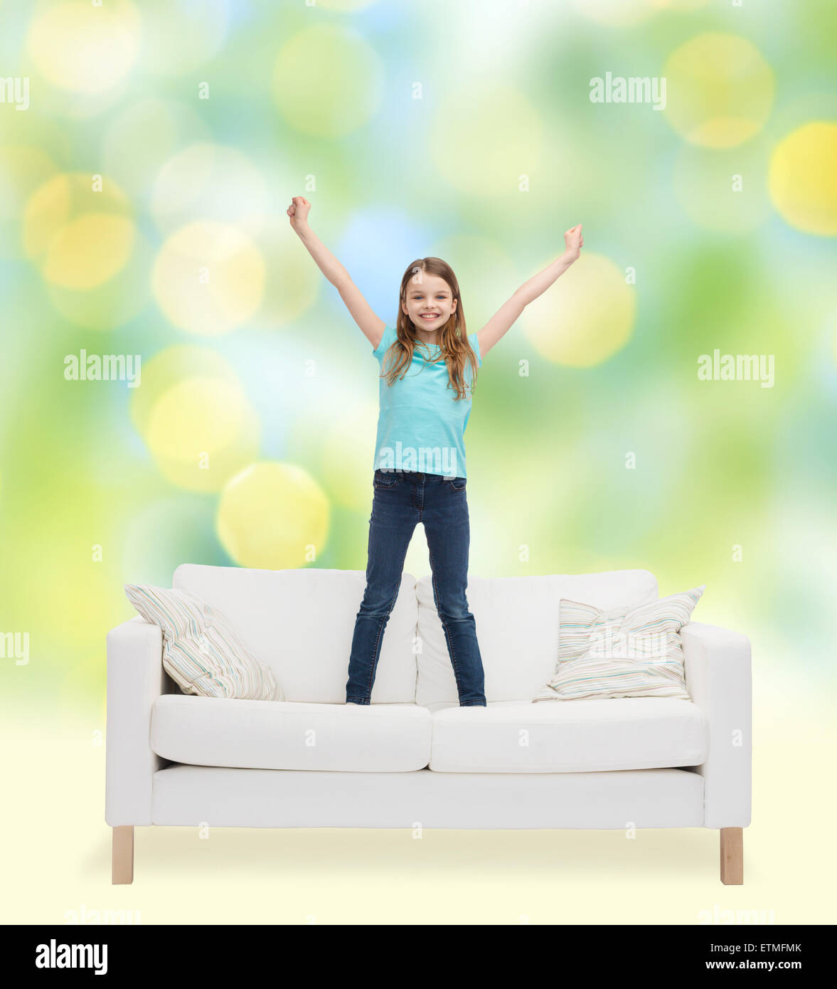 smiling little girl jumping on sofa Stock Photo - Alamy
