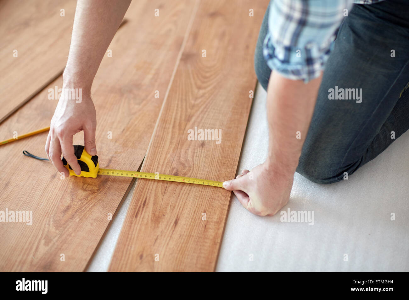 close up of male hands measuring flooring Stock Photo - Alamy