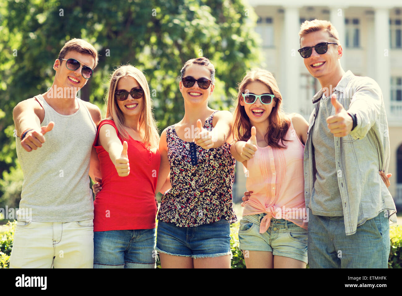 group of smiling friends showing thumbs up Stock Photo - Alamy