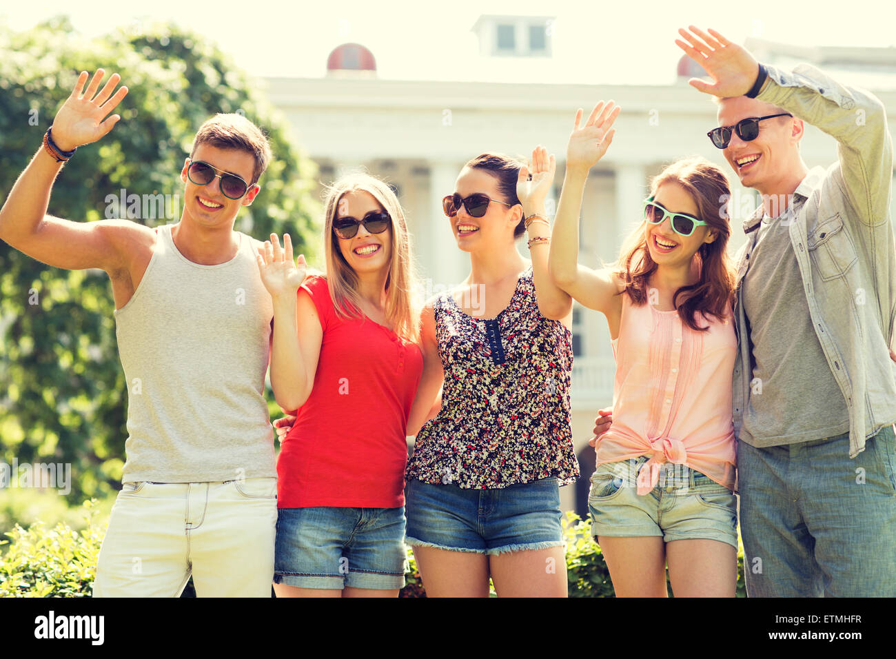 group of smiling friends waving hands outdoors Stock Photo - Alamy