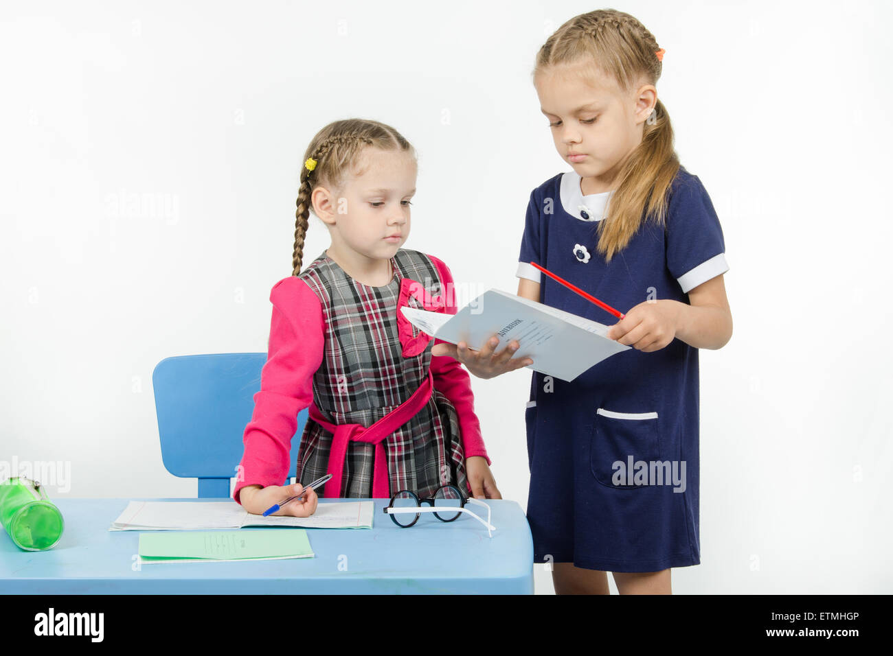 Two girls play school teacher and student Stock Photo - Alamy
