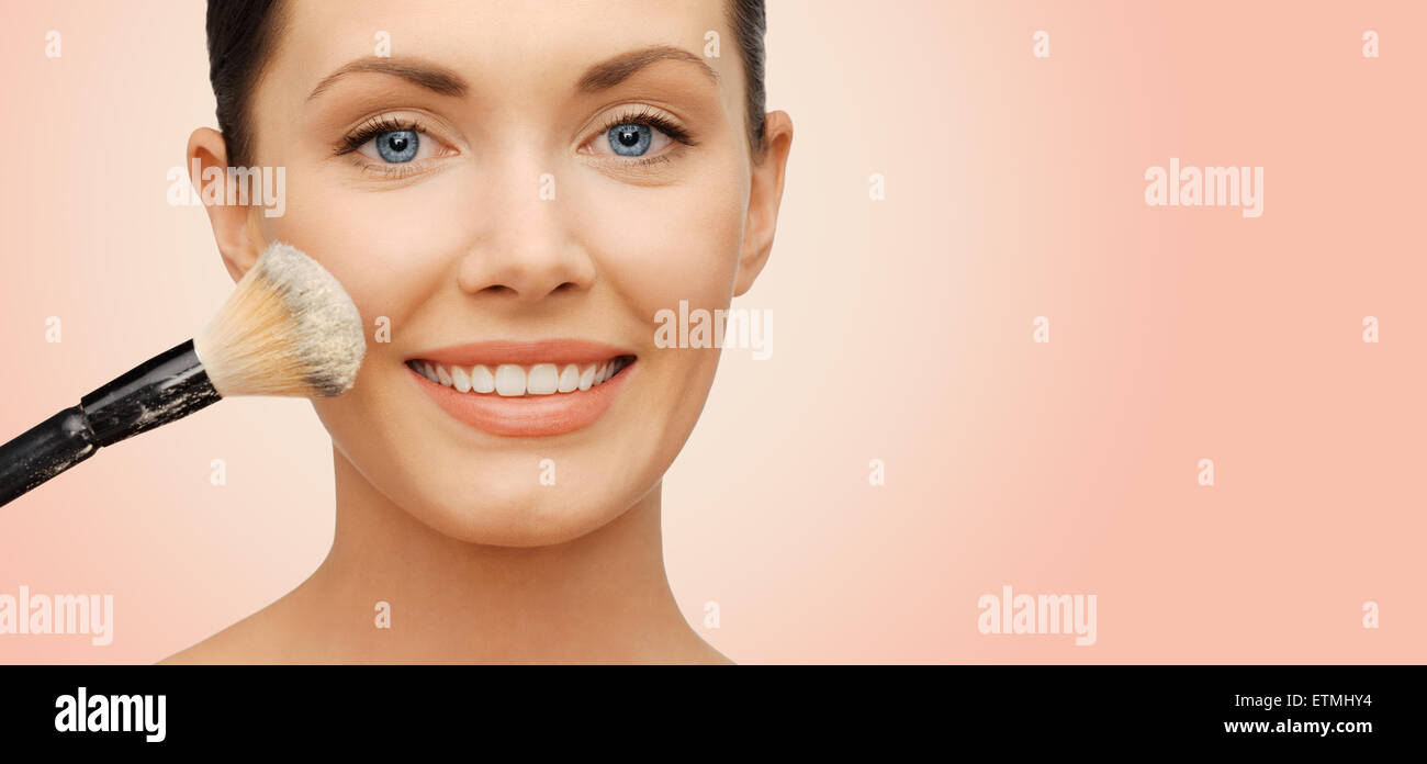 happy woman applying powder foundation with brush Stock Photo - Alamy