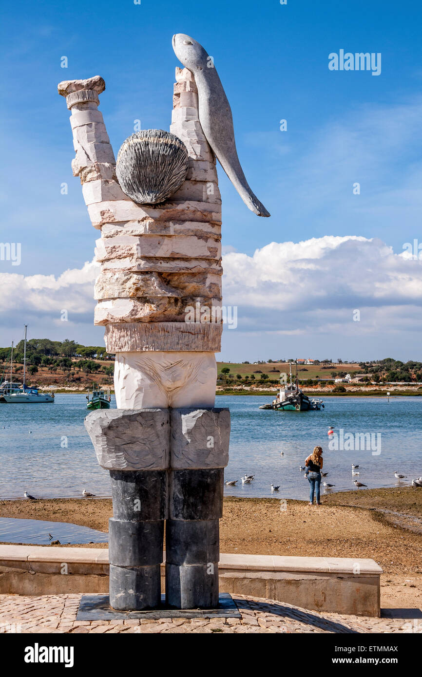 Statue of a fisherman holding a fish above his head made out of marble ...