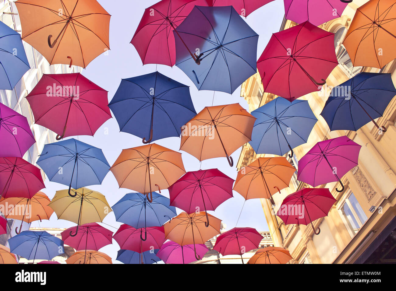 Colorful umbrellas over old building and sky Stock Photo - Alamy