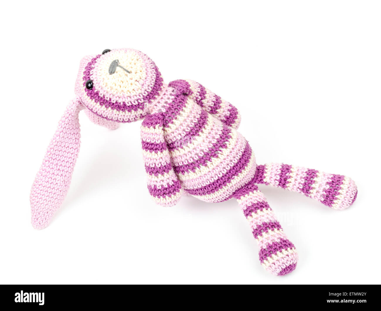 Knitted rabbit toy is sitting and looks up, photo isolated on white ...