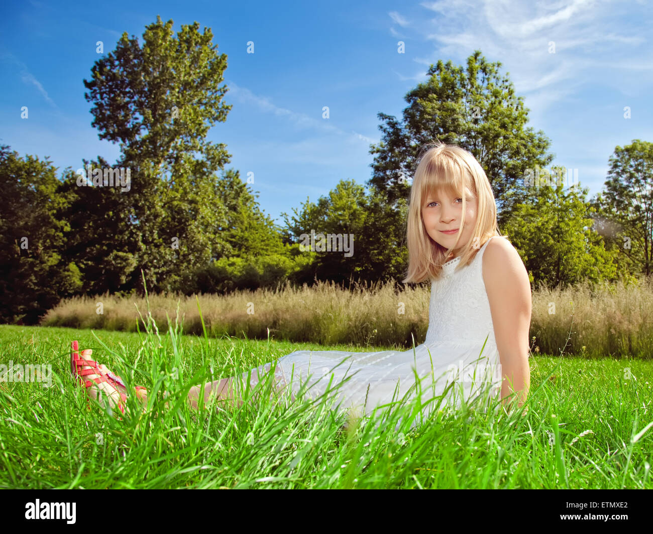 little girl sitting on green grass Stock Photo - Alamy