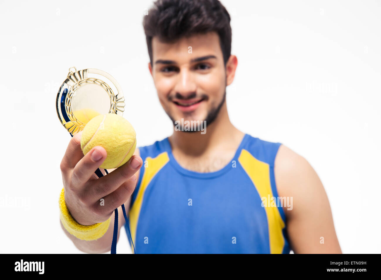Happy sports man holding medal and tennis ball isolated on a white ...