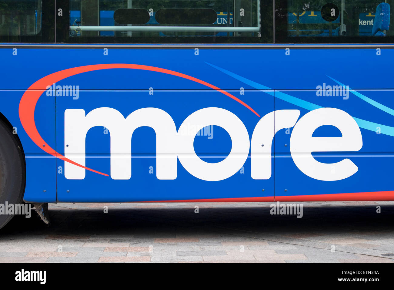 Red and white graphic of the word MORE on the side of a blue public ...