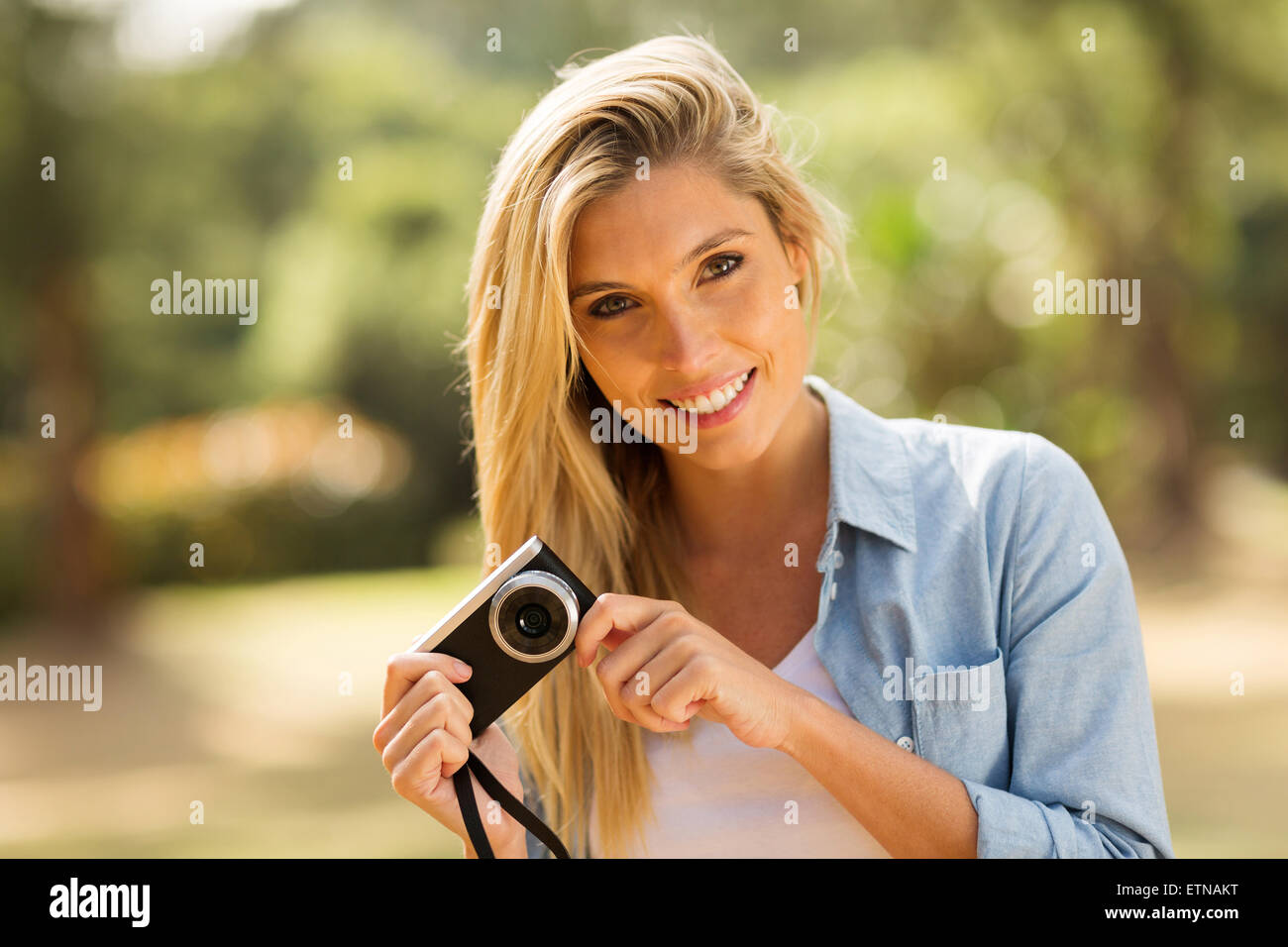 happy young woman holding a camera at the park Stock Photo - Alamy