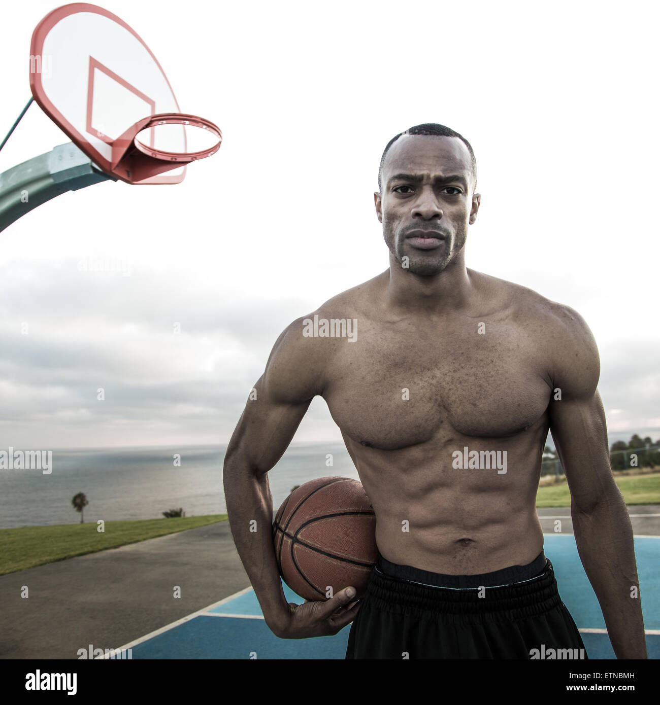 Portrait of a young man holding a basketball in a park, Los Angeles ...