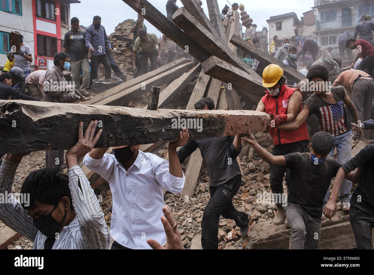 Rescue teams and volunteers removing wood and rubble from a collapsed ...