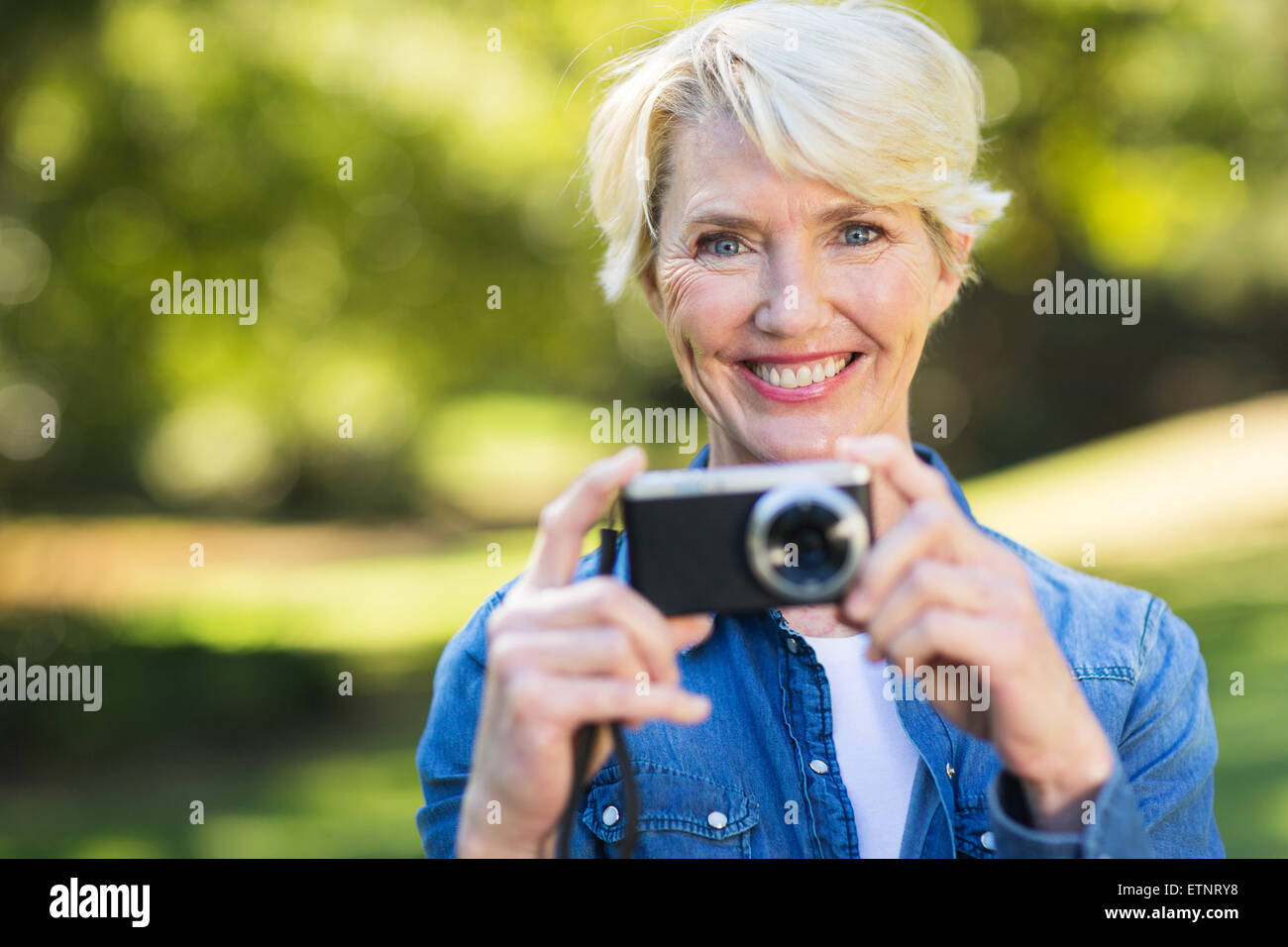 pretty middle aged woman with her camera at the park Stock Photo - Alamy