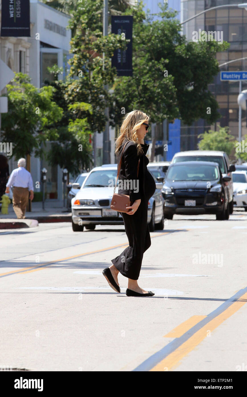Pregnant Molly Sims showing her baby bump in a black maxi dress crosses ...