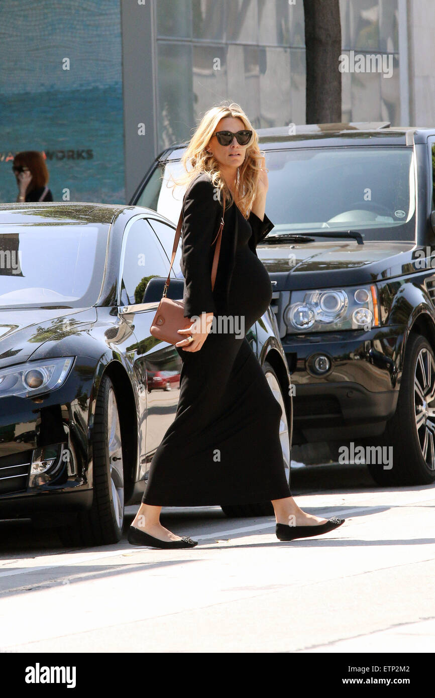 Pregnant Molly Sims showing her baby bump in a black maxi dress crosses ...