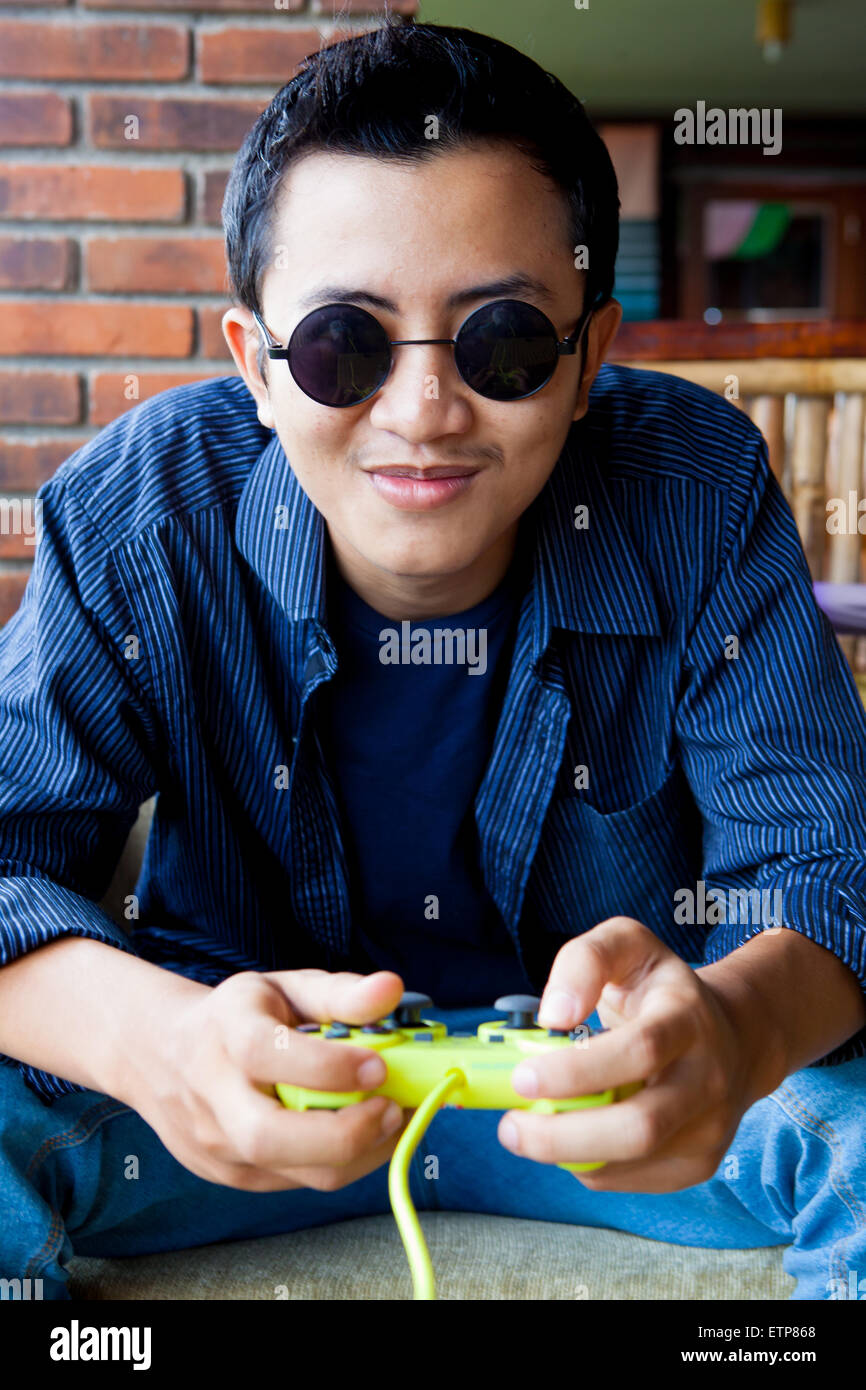 Boy wearing black eye glass and playing video games Stock Photo - Alamy