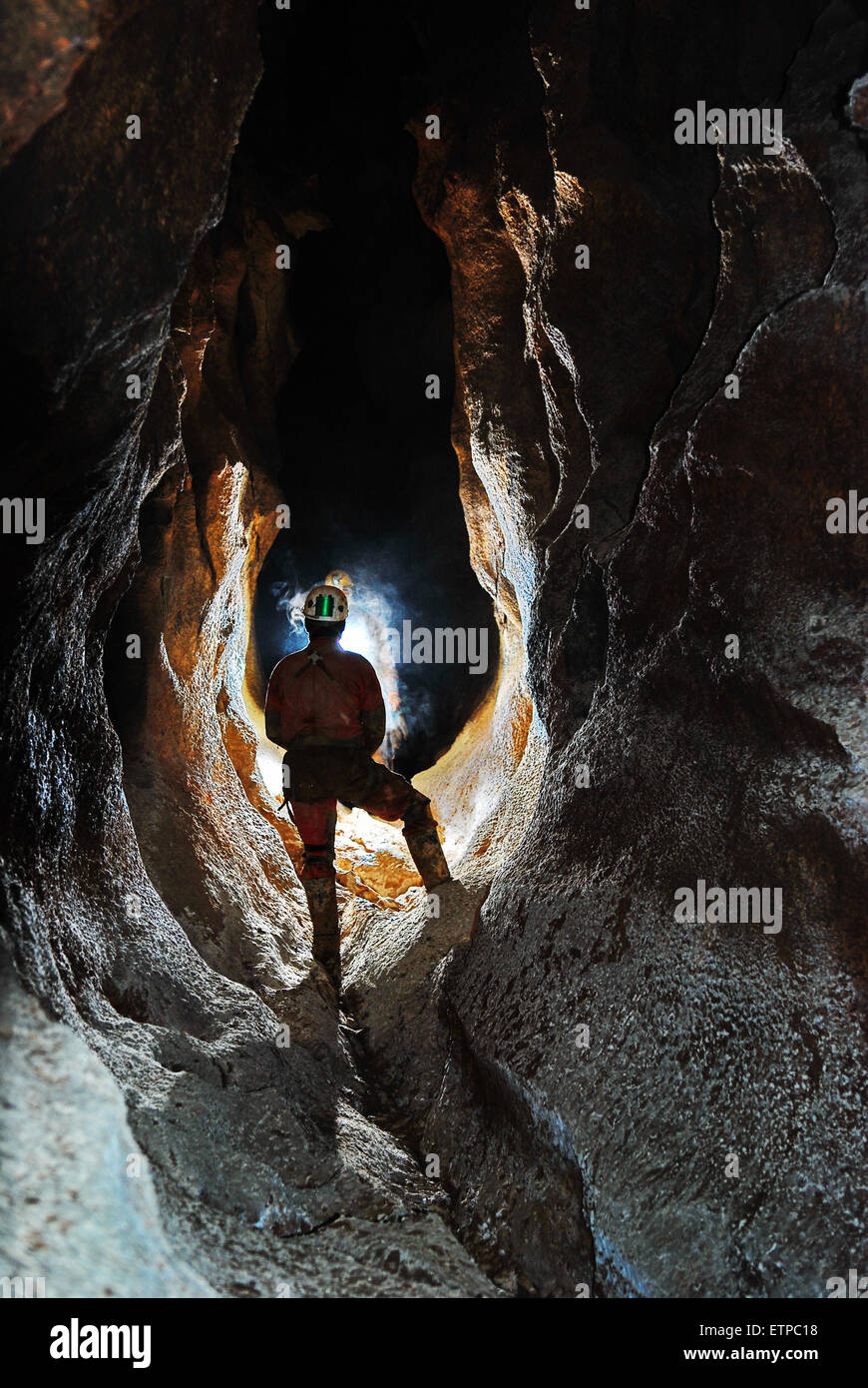 Cave explorer in a typical couse of a cave Stock Photo - Alamy