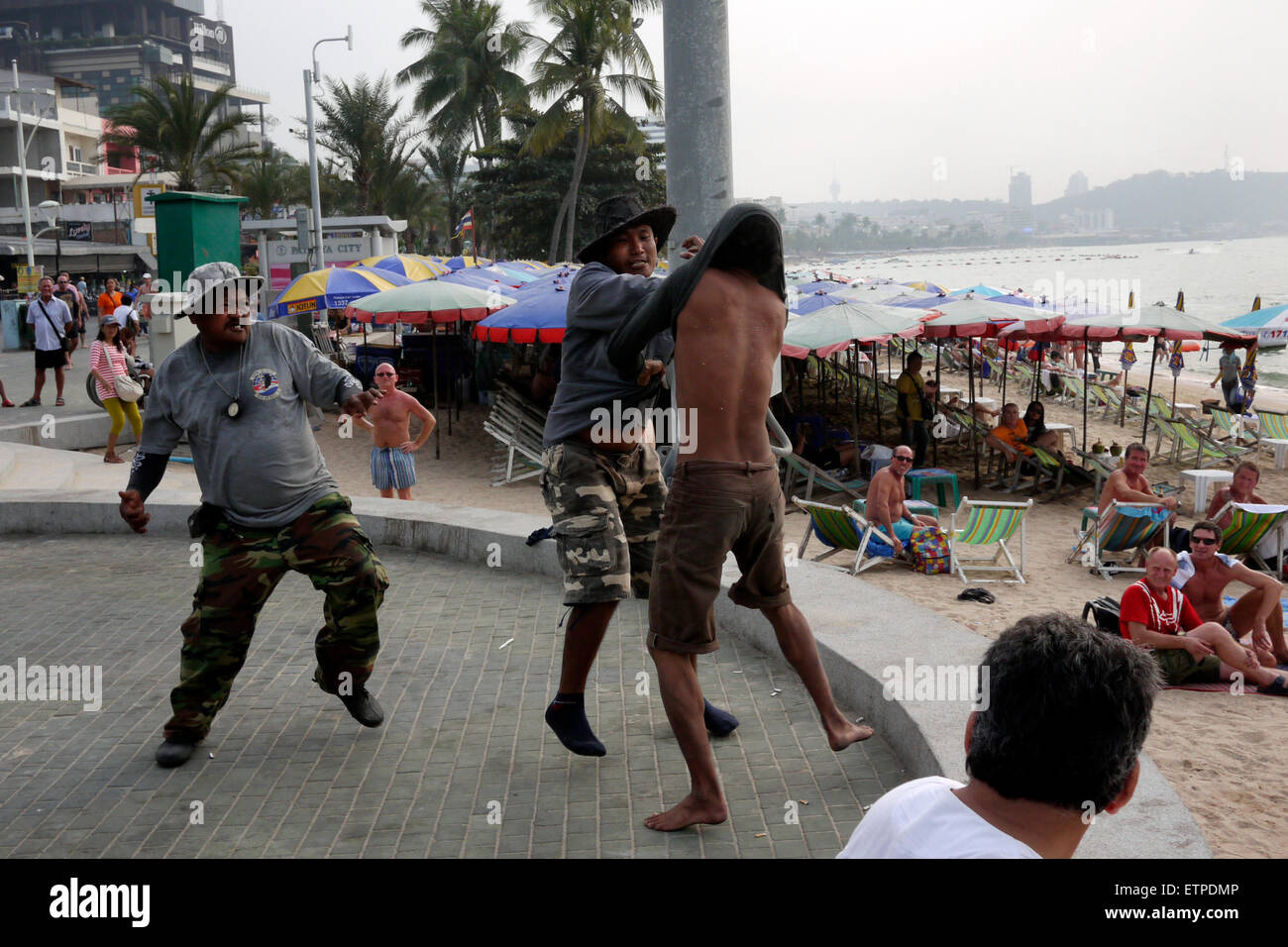 Males fighting near the beach in Pattaya Thailand while tourists look ...