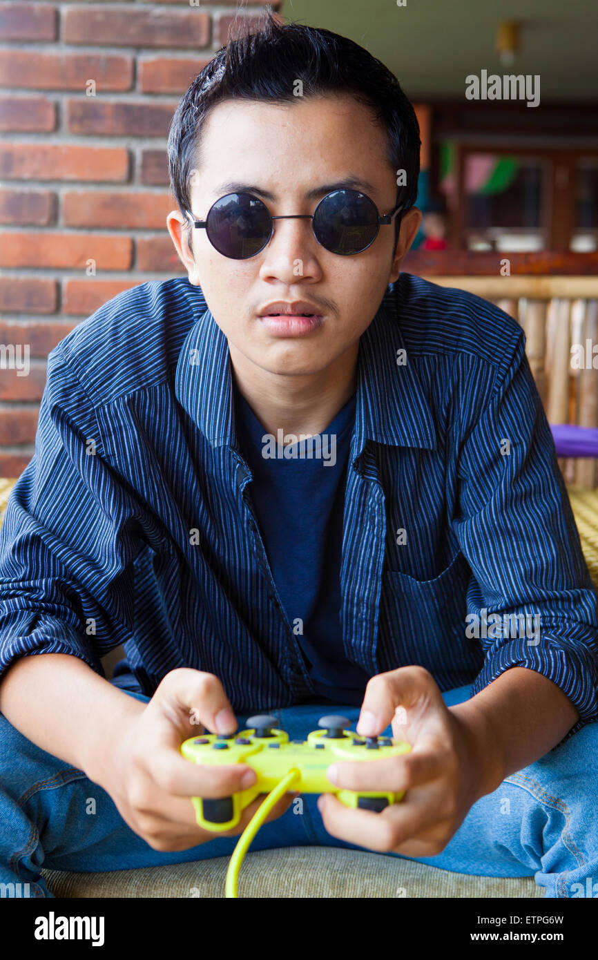 Boy wearing black eye glass and playing video games Stock Photo - Alamy