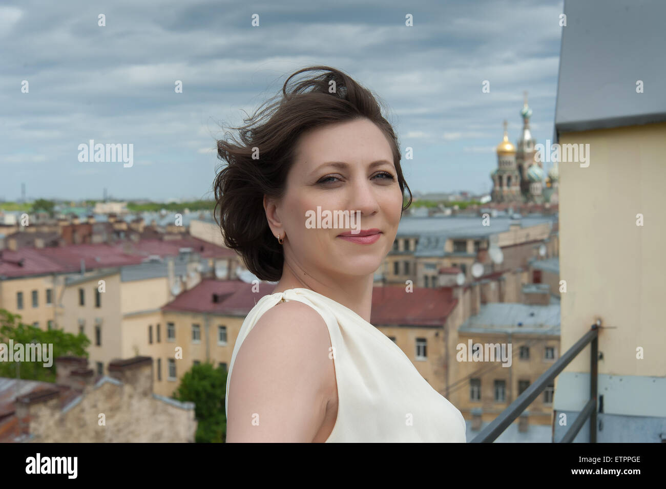 Gorgeous woman smiling in the wind on the roof Stock Photo - Alamy