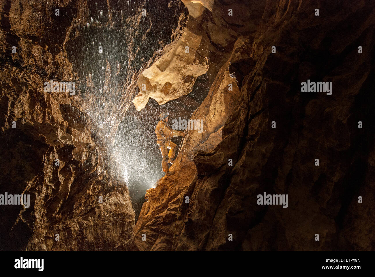 Cave explorer in dripping water of a cave Stock Photo - Alamy