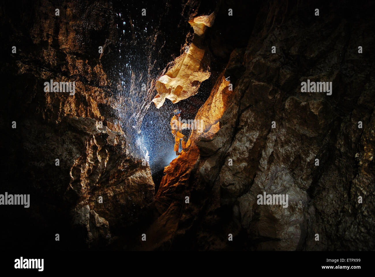 Cave explorer in dripping water of a cave Stock Photo - Alamy