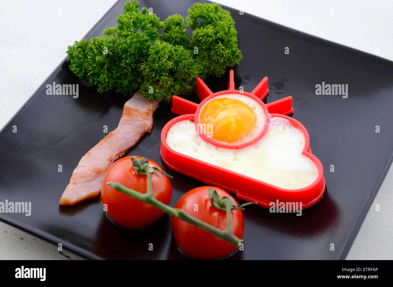 Bright happy breakfast with sunny egg, bacon tree with parsley leaves ...