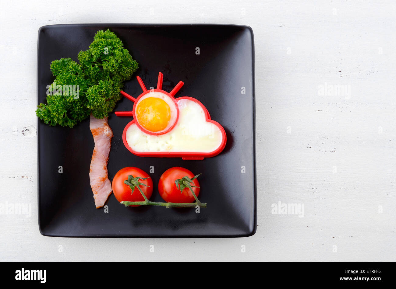 Bright happy breakfast with sunny egg, bacon tree with parsley leaves ...