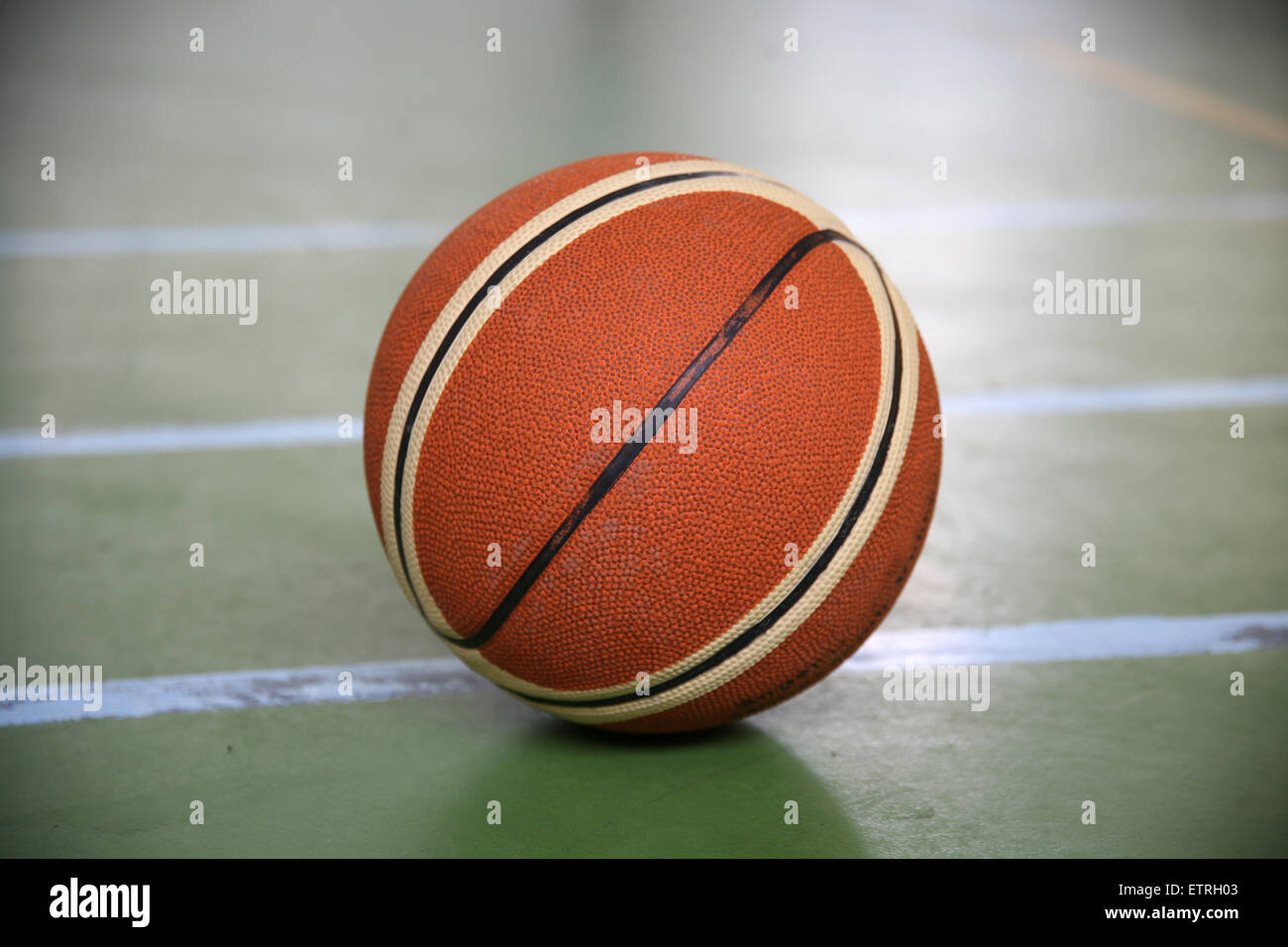 Classic orange colored basketball on the gym floor as a background ...
