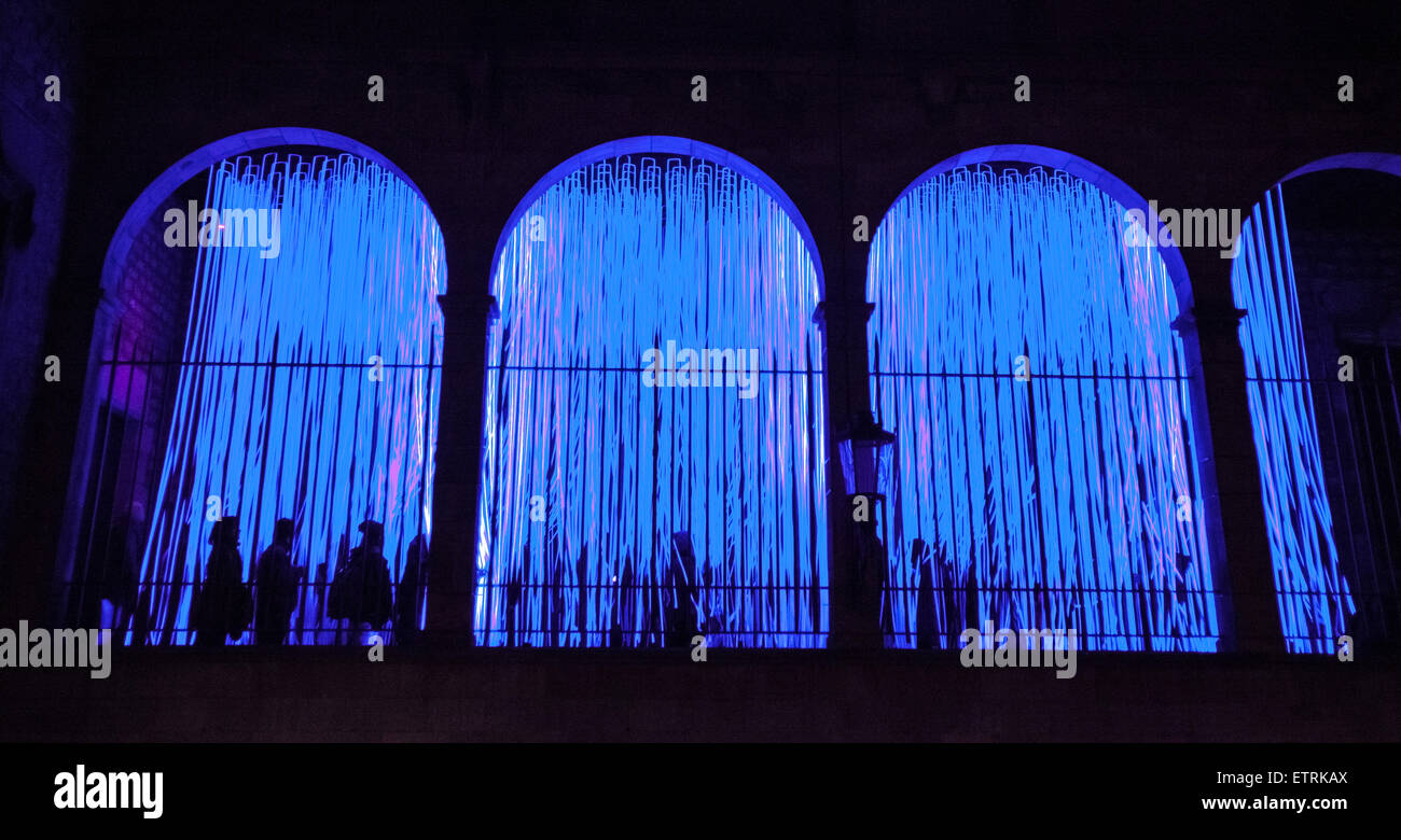 Silhouette of people walking in Blue light, installation on square in ...