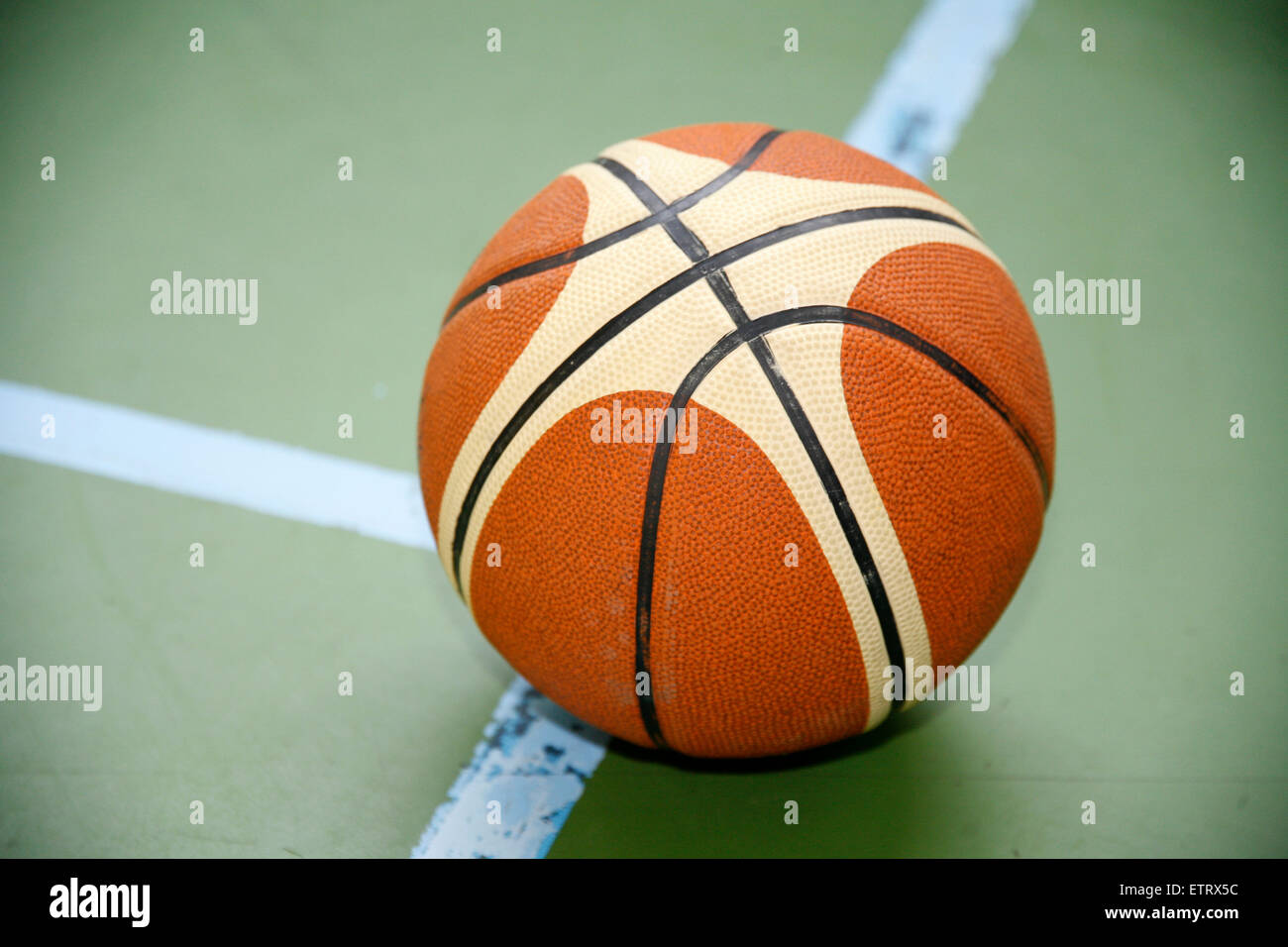 Classic orange colored basketball on the gym floor as a background ...