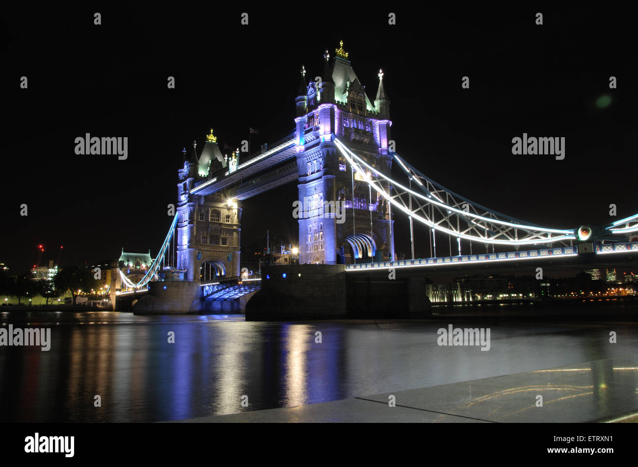 Night photo of London Bridge taken at night while lit up with purple ...