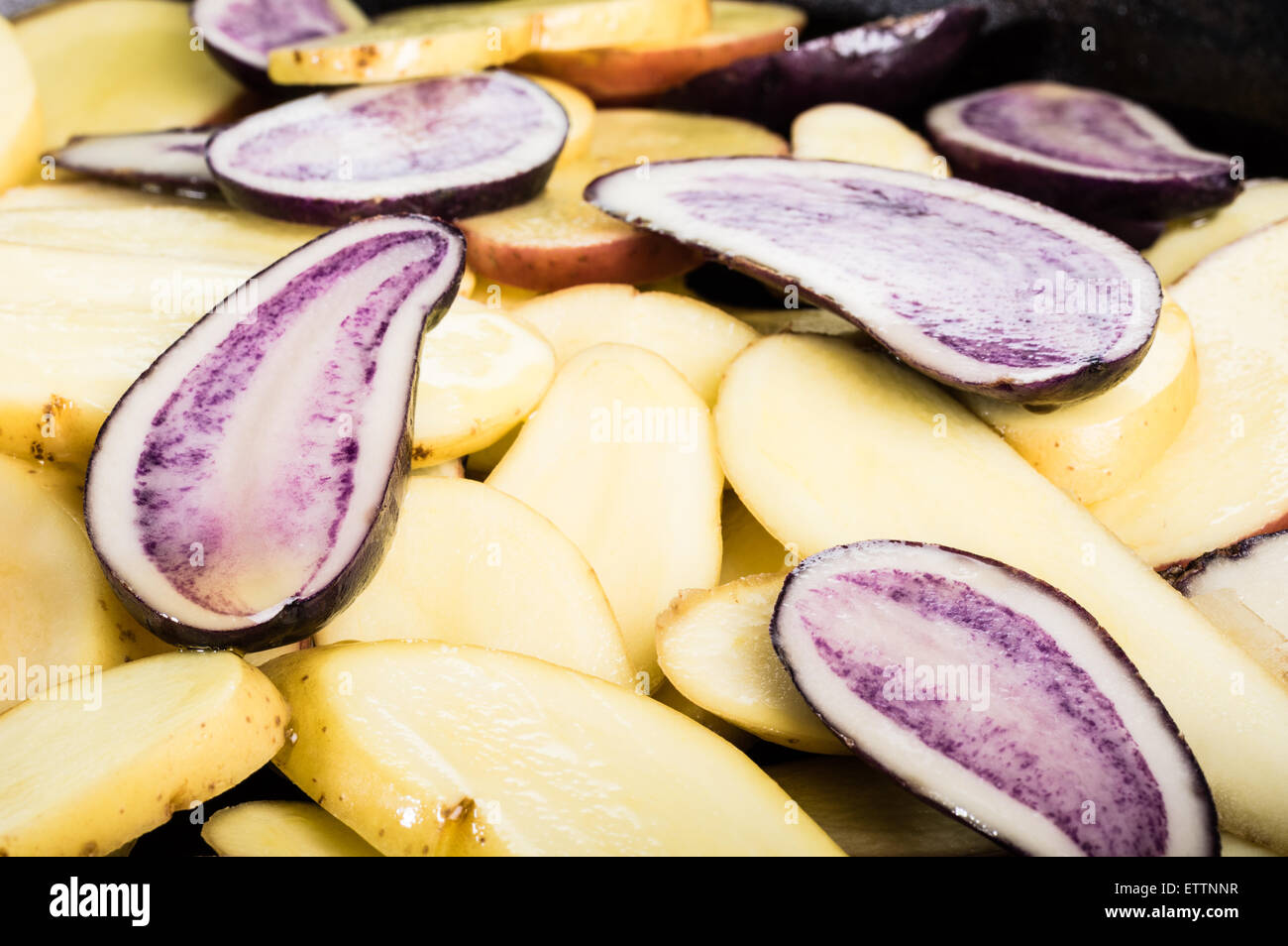 Potato slices in frying pan both white and blue Stock Photo - Alamy