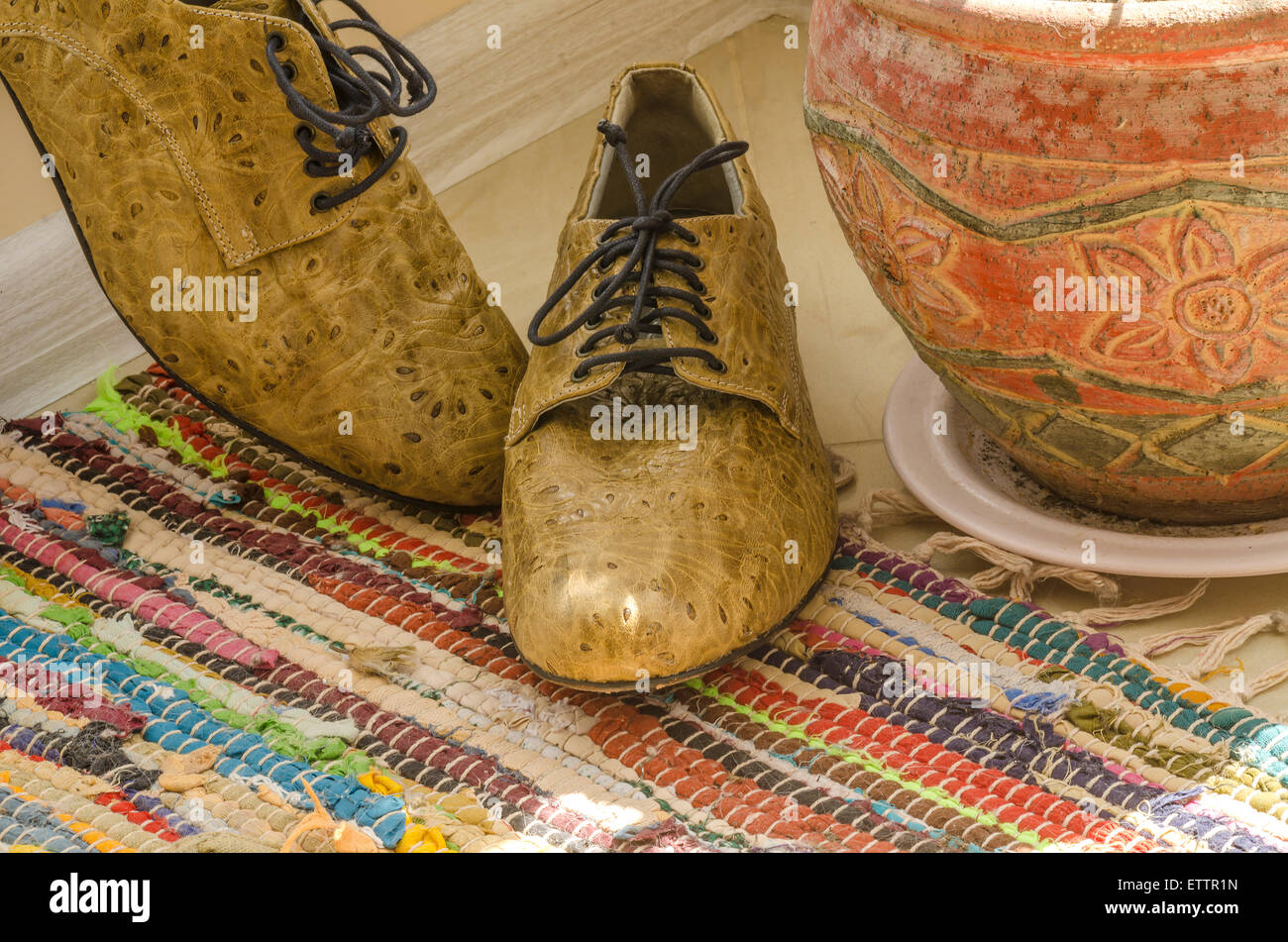 Still life with man shoes, flower pot and woven rug. Rustic style Stock ...